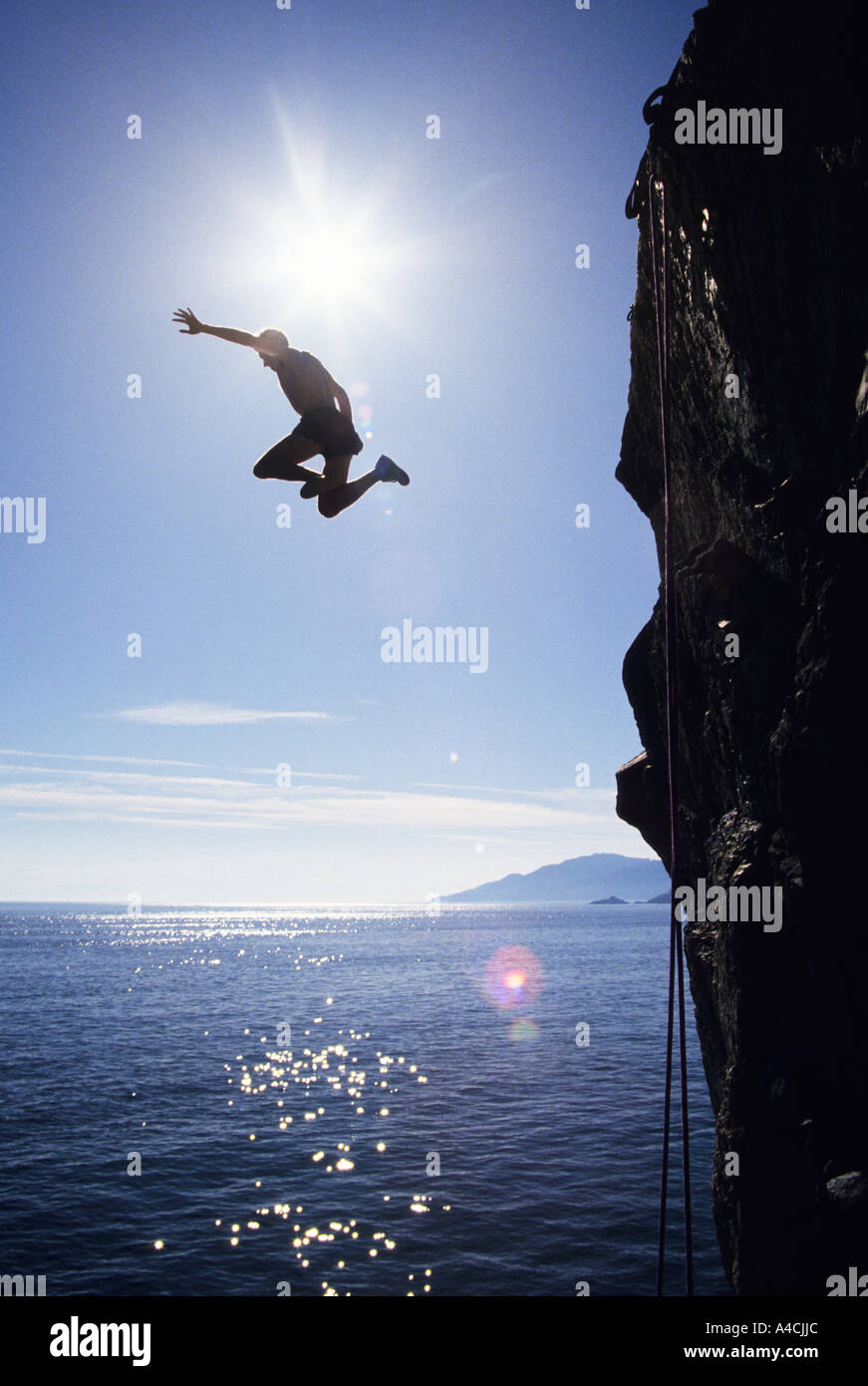 Man jumping from cliff Stock Photo - Alamy