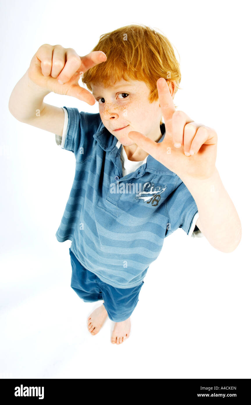 Ginger Haired boy dressed in blue holding his hands as a frame Stock ...