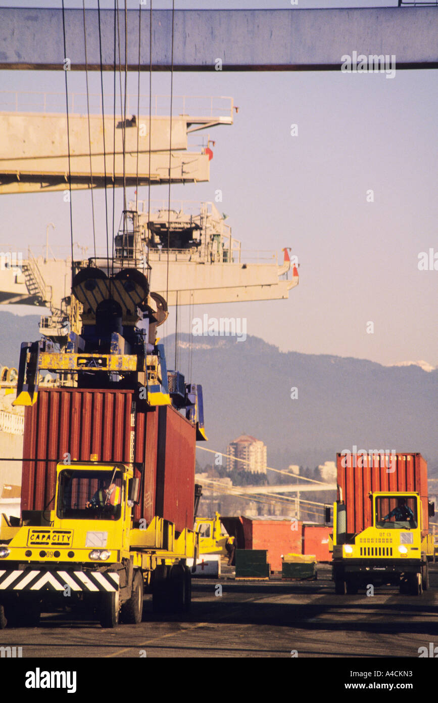 Trucks moving shipping containers into position for loading Stock Photo ...
