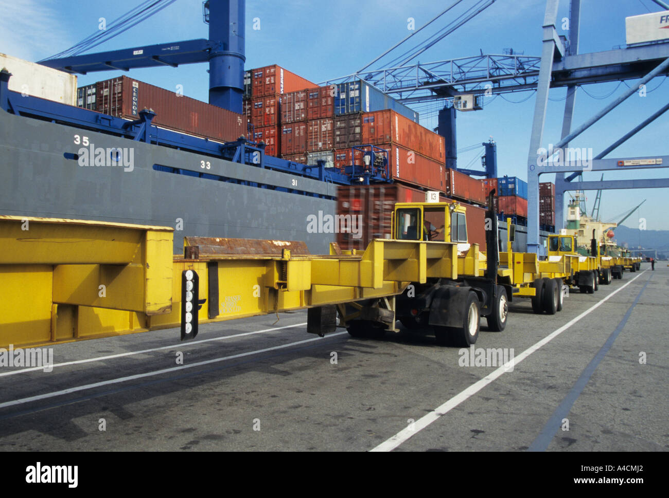 Transport trucks waiting for container off loading from a ship Stock ...