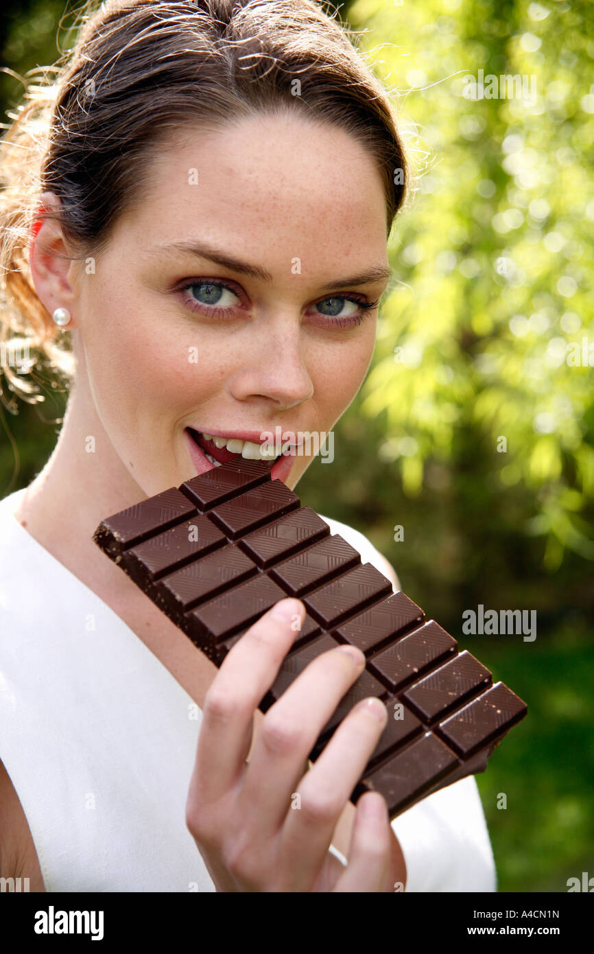 Young woman eating chocolate Stock Photo - Alamy