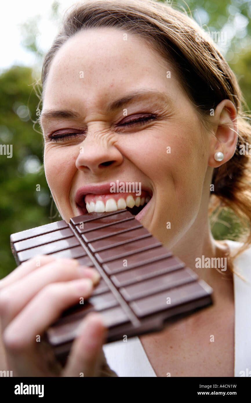 Young woman eating chocolate Stock Photo - Alamy