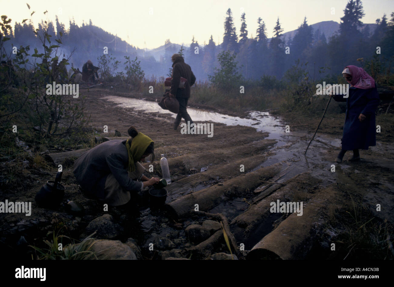 CHUBERI PASS, GEORGIA, OCTOBER 1993: A woman fills conatiners from a ...