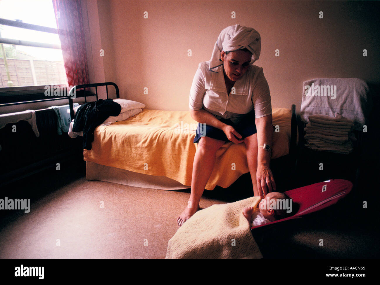 An inmate, Mary, sits in her room and reaches out to her baby Jonathan ...
