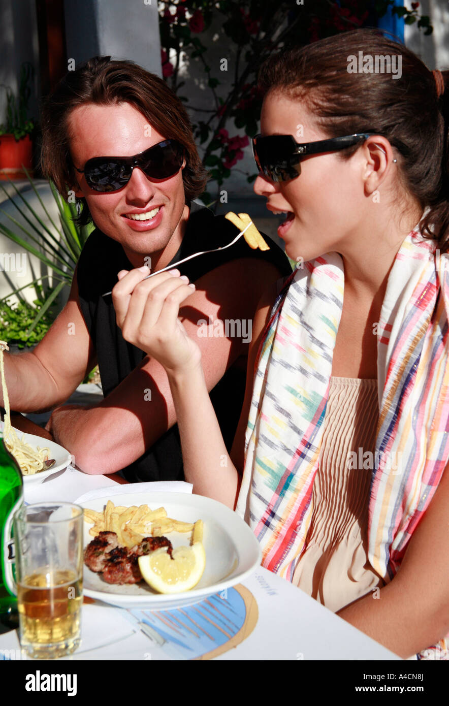 Young couple eating at restaurant table Stock Photo - Alamy