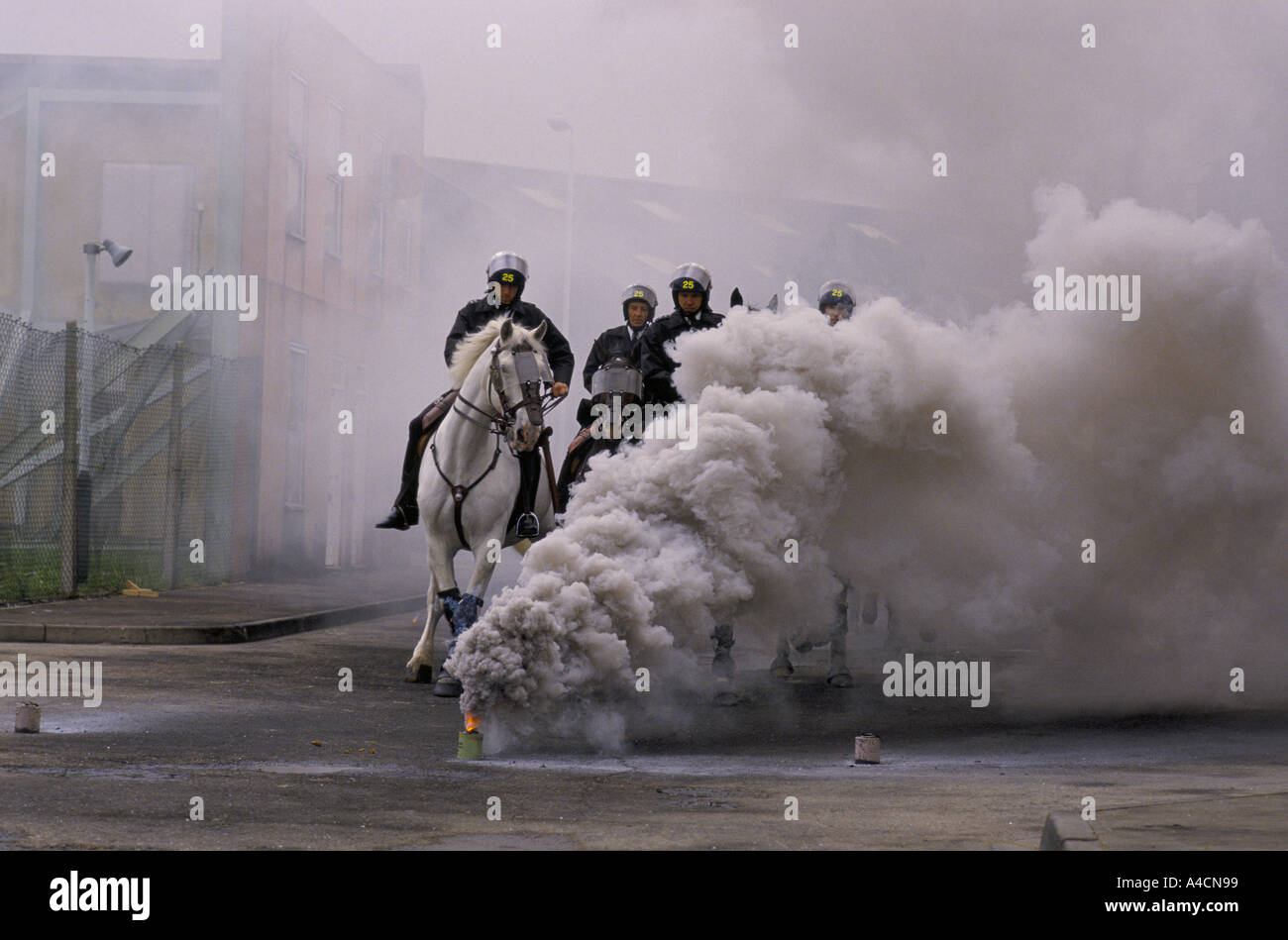 Mounted police ride their horses through smoke flares as part of riot ...