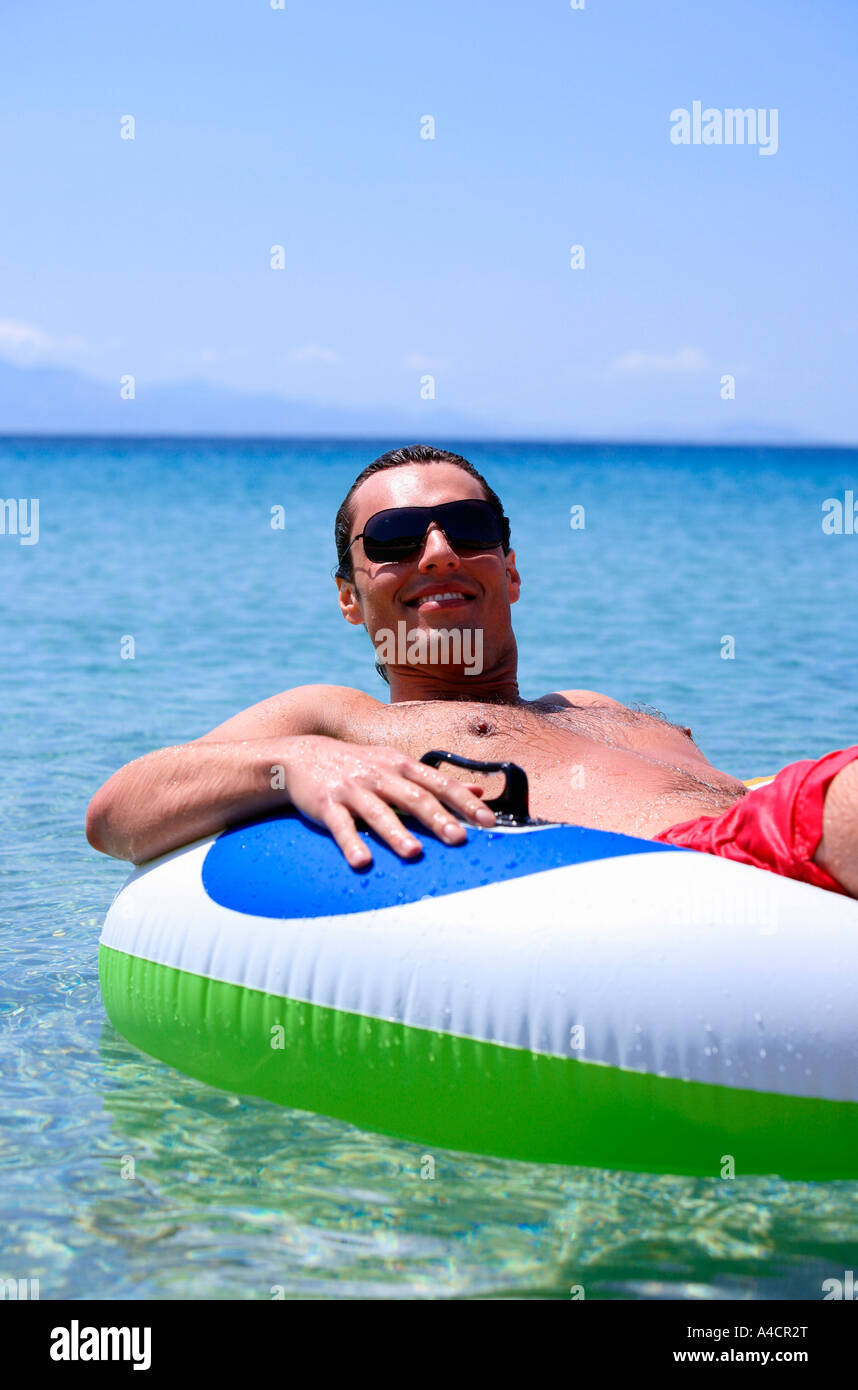 Young man in water on inflatable life ring Stock Photo - Alamy