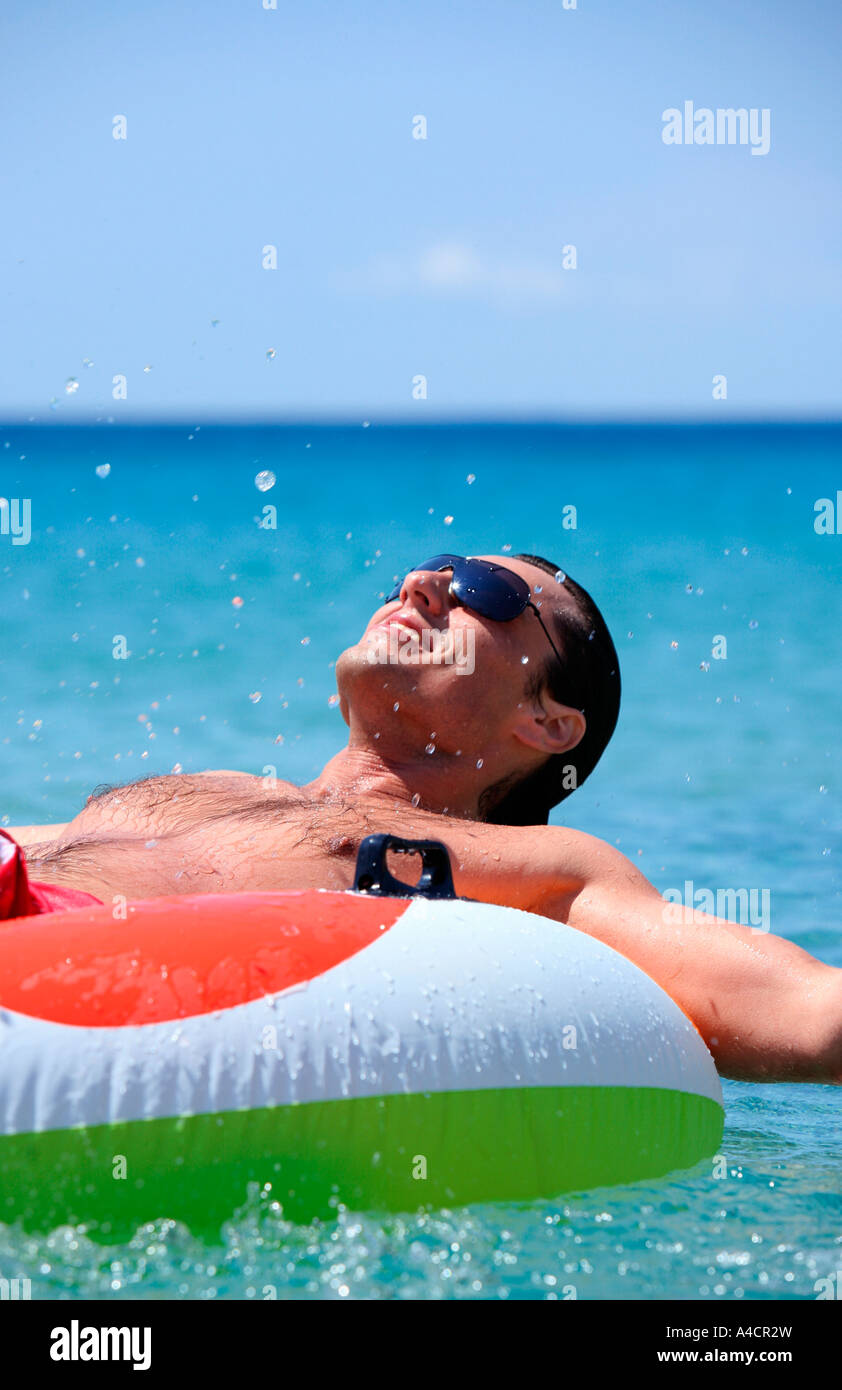 Young man in water on inflatable life ring Stock Photo - Alamy