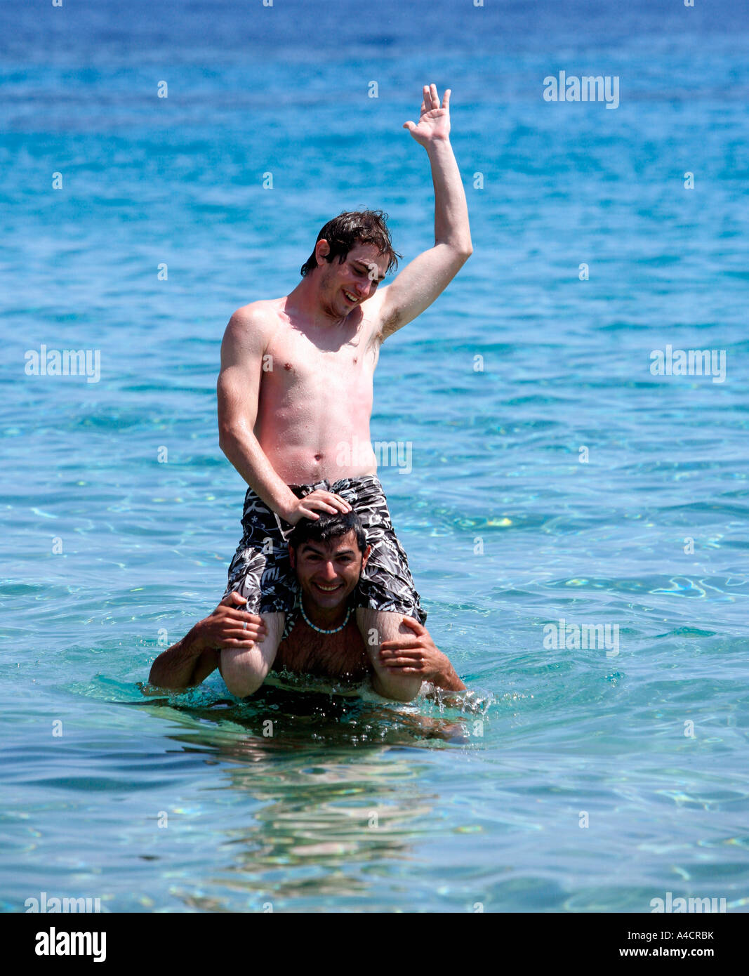 Two young men playing in the water Stock Photo - Alamy