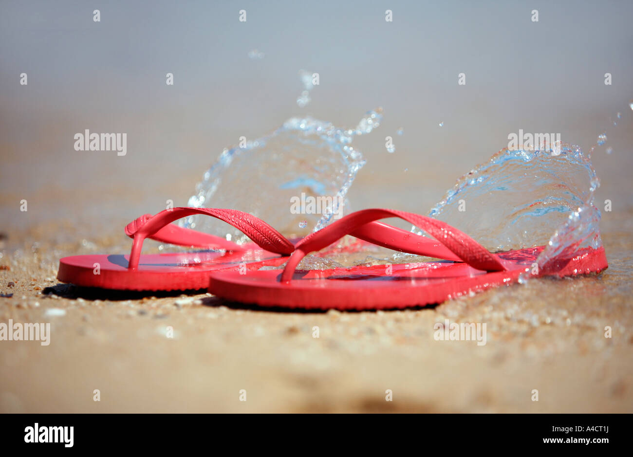 Flip flops on the beach with water splashing Stock Photo - Alamy