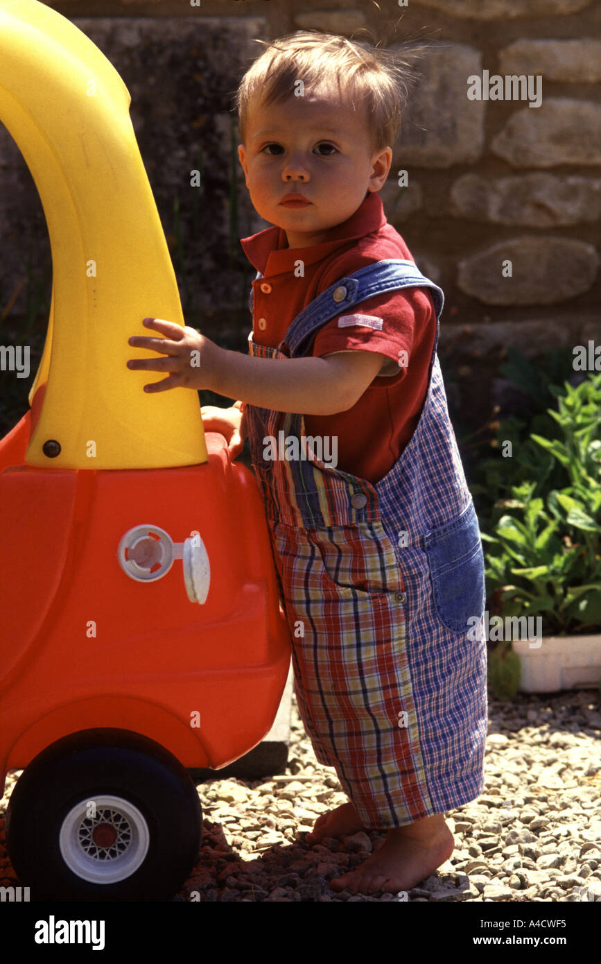 Toddler standing next to plastic toy car Stock Photo - Alamy
