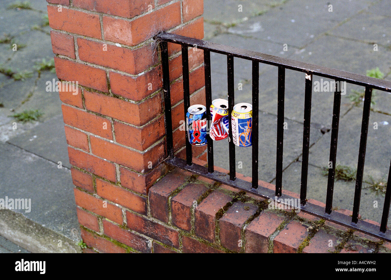 three soda cans trapped in wall railings Stock Photo - Alamy