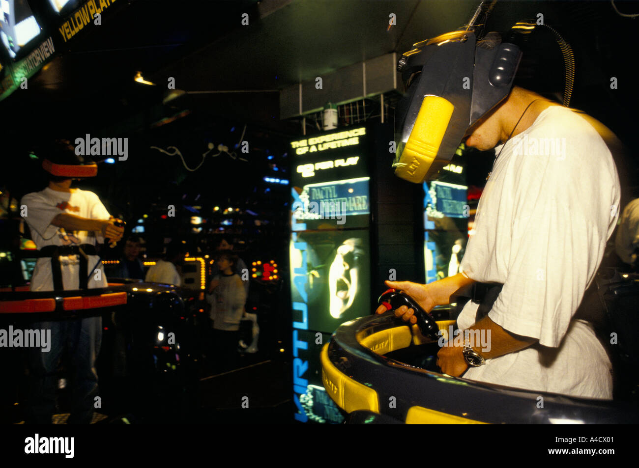 A boy wears a 3D visor to play a virtual reality video game in three ...