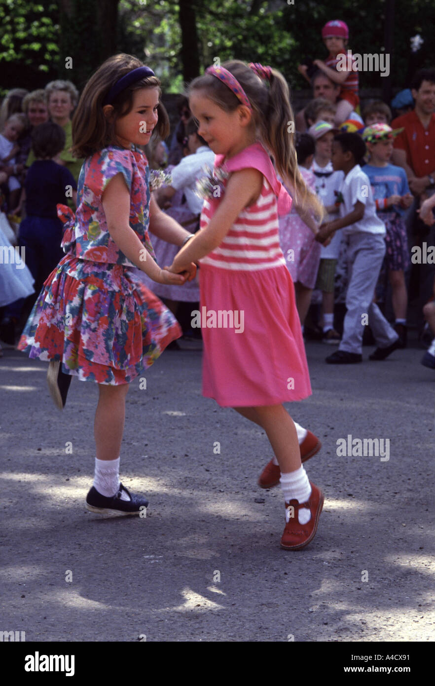 Two girls dancing together at a Village Fair Stock Photo - Alamy
