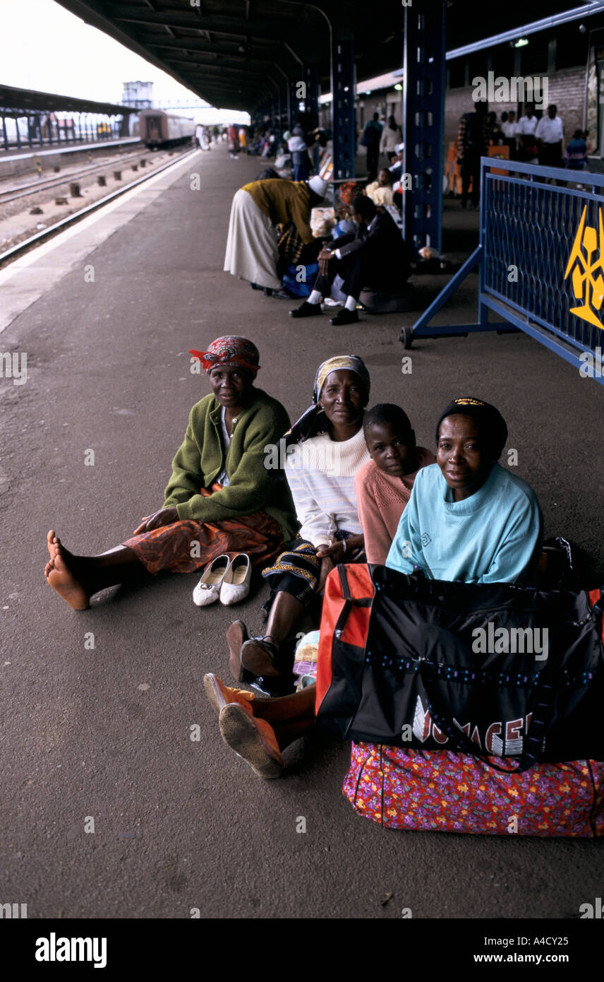 People sitting on the platform waiting for the train to arrive ...
