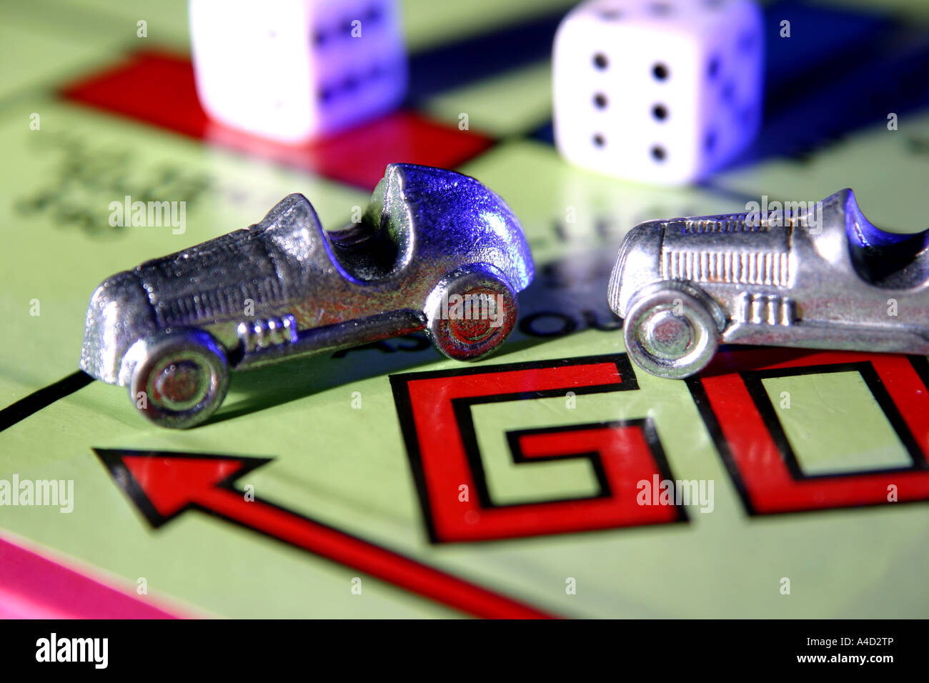 Dice and cars on Monopoly game board Stock Photo - Alamy