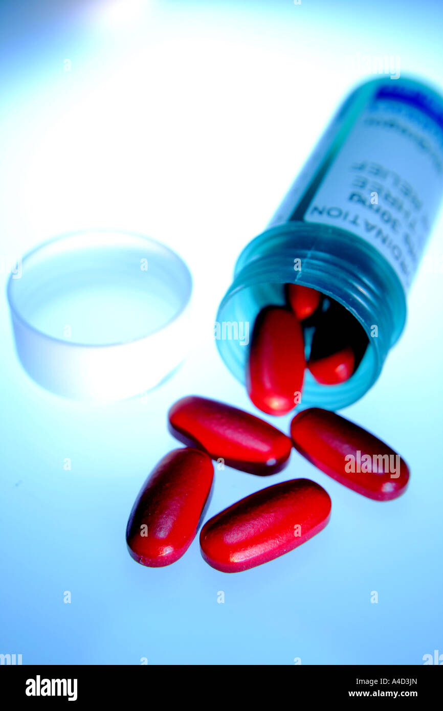 Red tablets spilling from plastic prescription bottle Stock Photo - Alamy