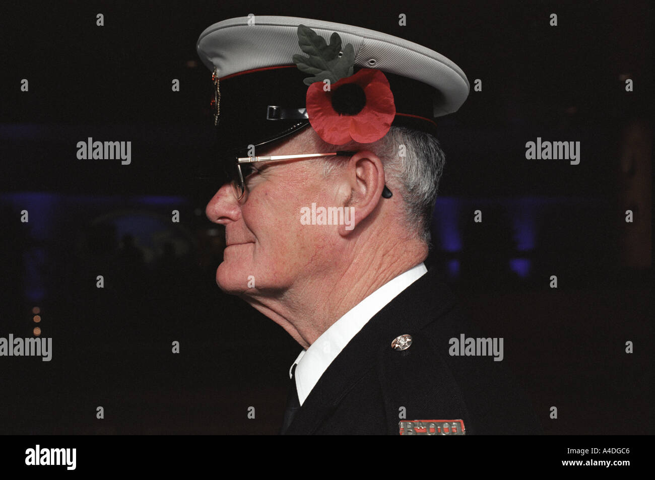 A concierge in uniform with a rememberance day red poppy in his cap ...