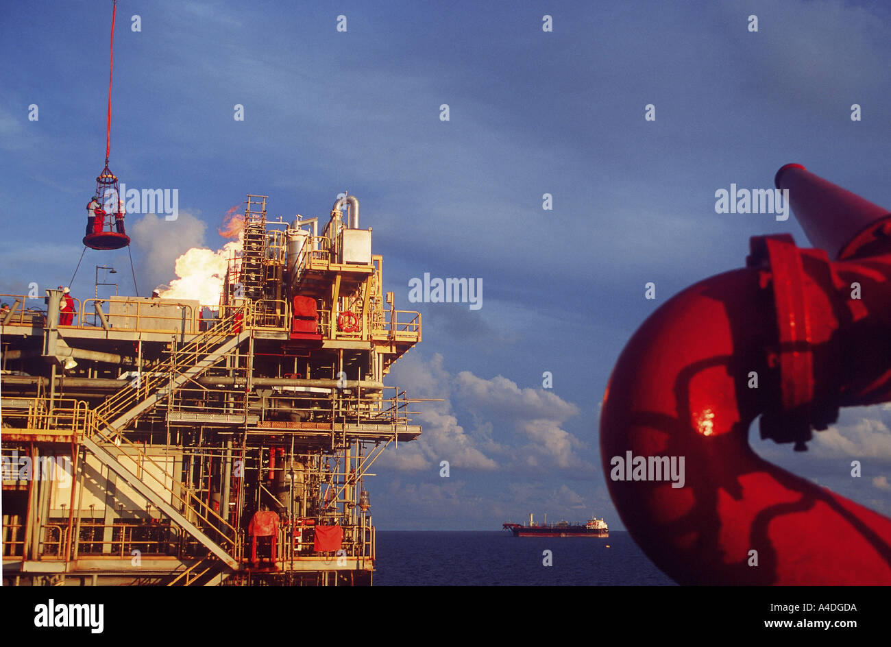 Oil workers being transfered by hanging basket from the the oil ...