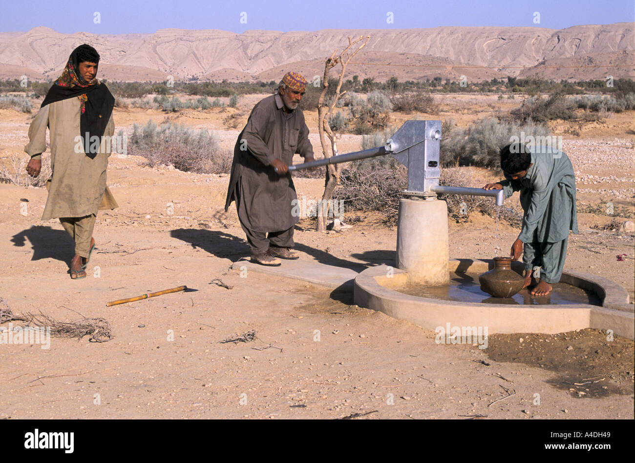 Village men use a water hand pump. Karchat area, Sindh province ...