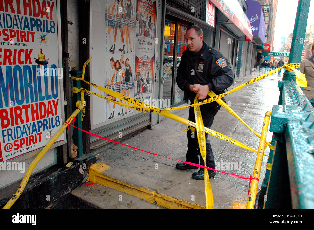 An NYPD officer uses tape to block the entrance to a subway station ...