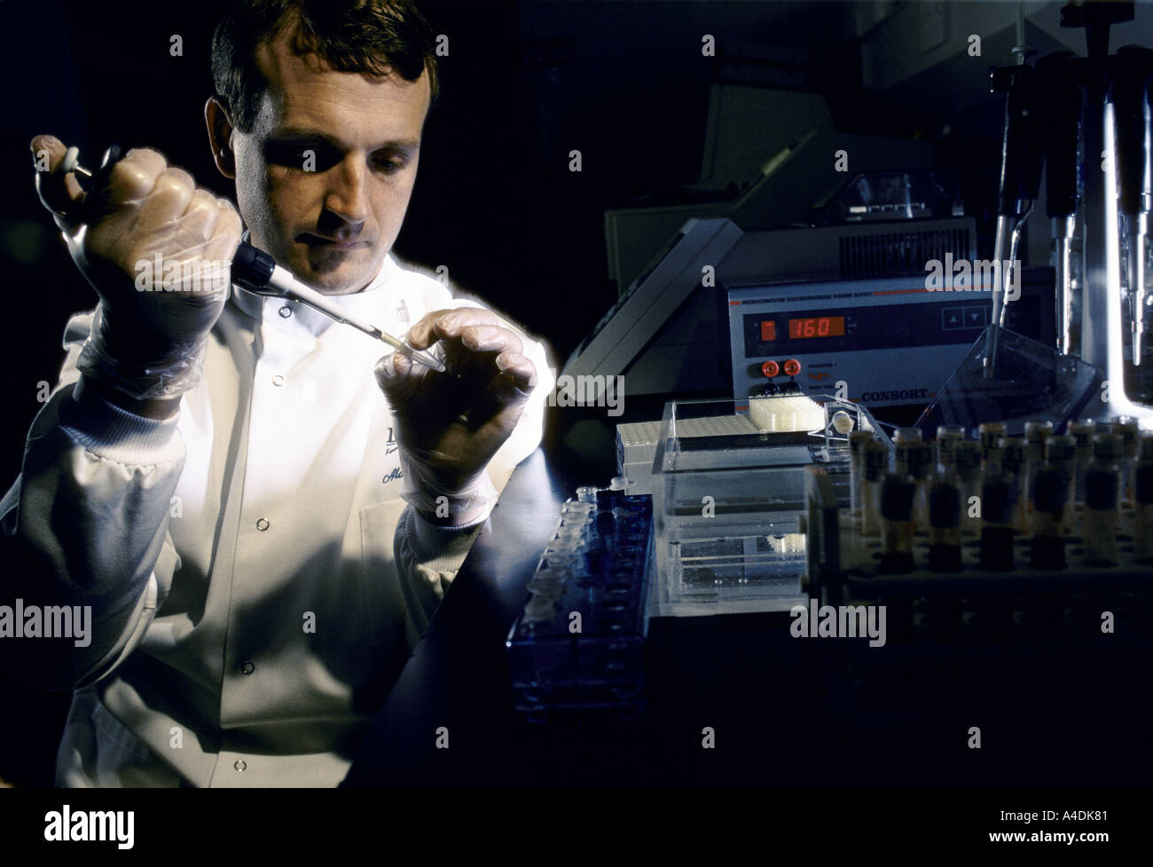 A white coated male worker in a DNA research laboratory in Cambridge ...