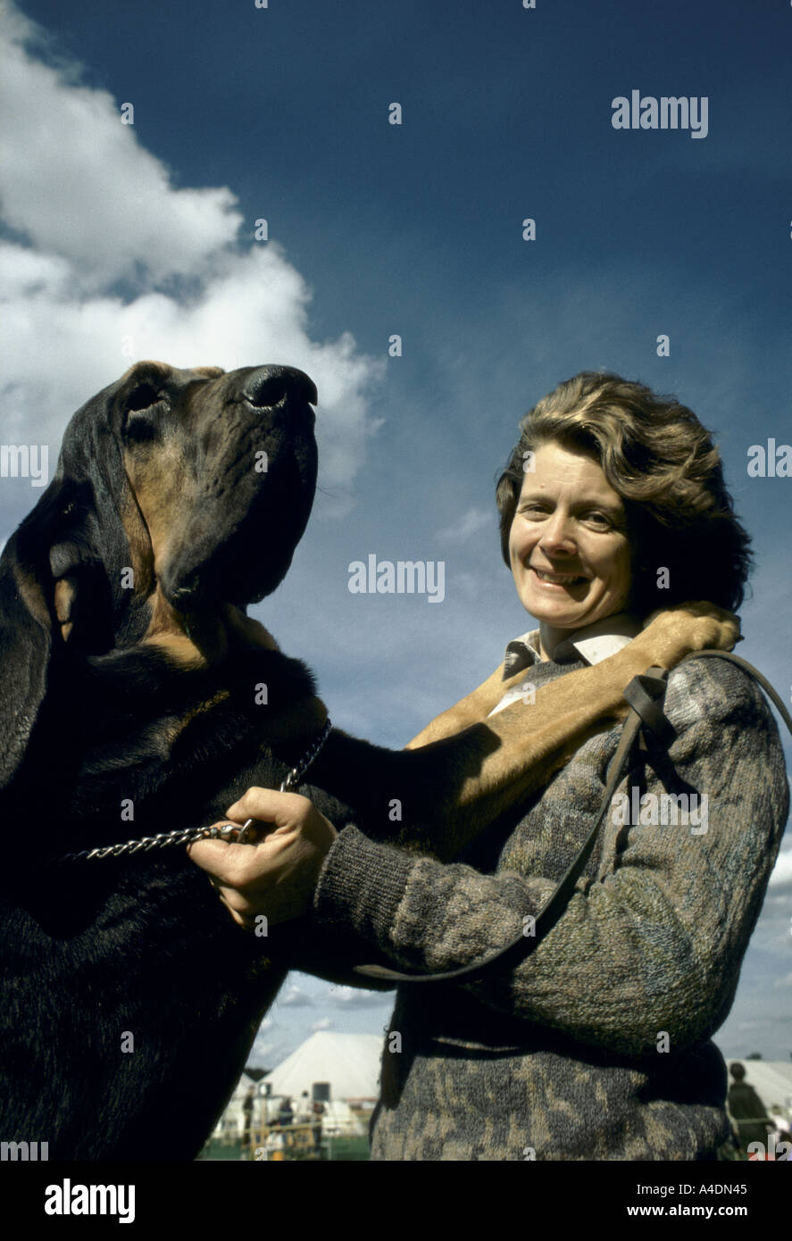 A dog raised up on its hind legs resting its front paws on a woman's ...