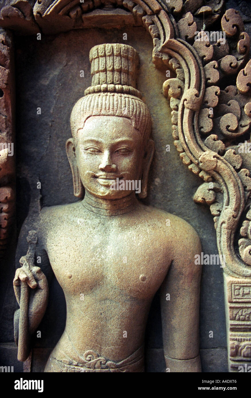 Fine carved stone detail of a male divinity at the temple Banteay Srei ...