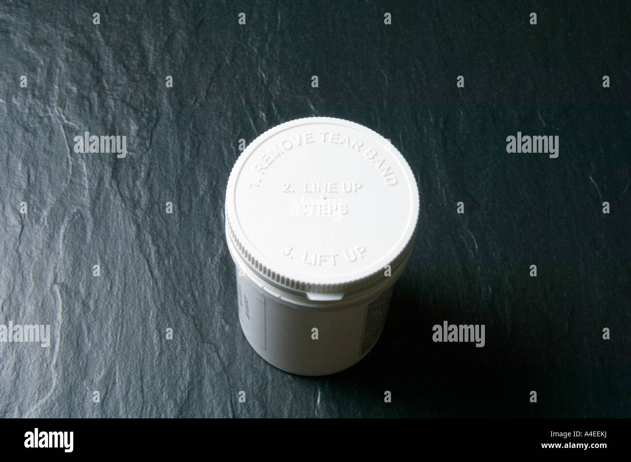 A medical pill drum container with instructions for opening on top ...