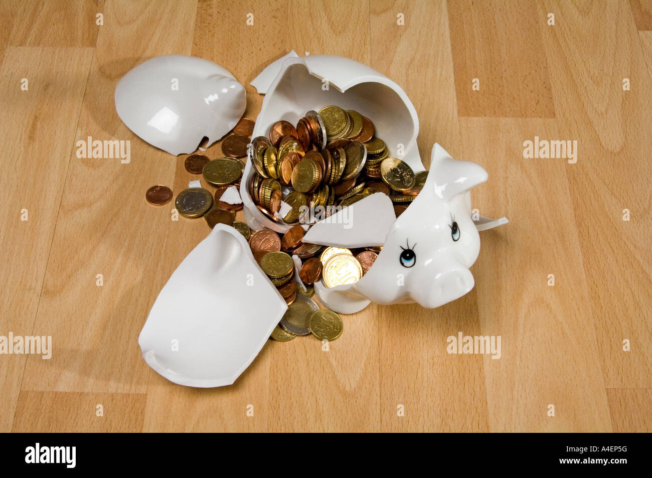 A smashed money piggy bank with coins falling out Stock Photo - Alamy