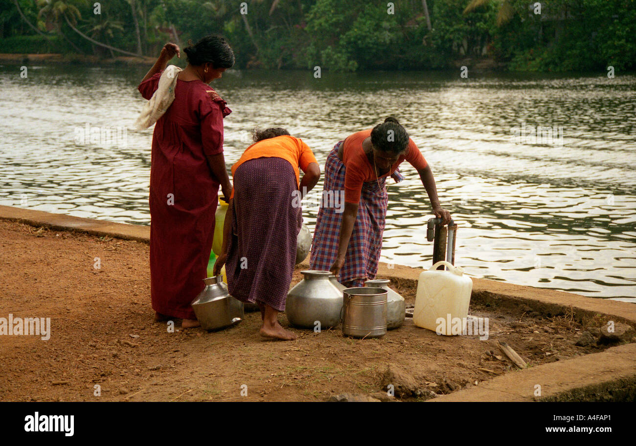 Women collecting water from a stand pipe on the backwaters in Kerala ...