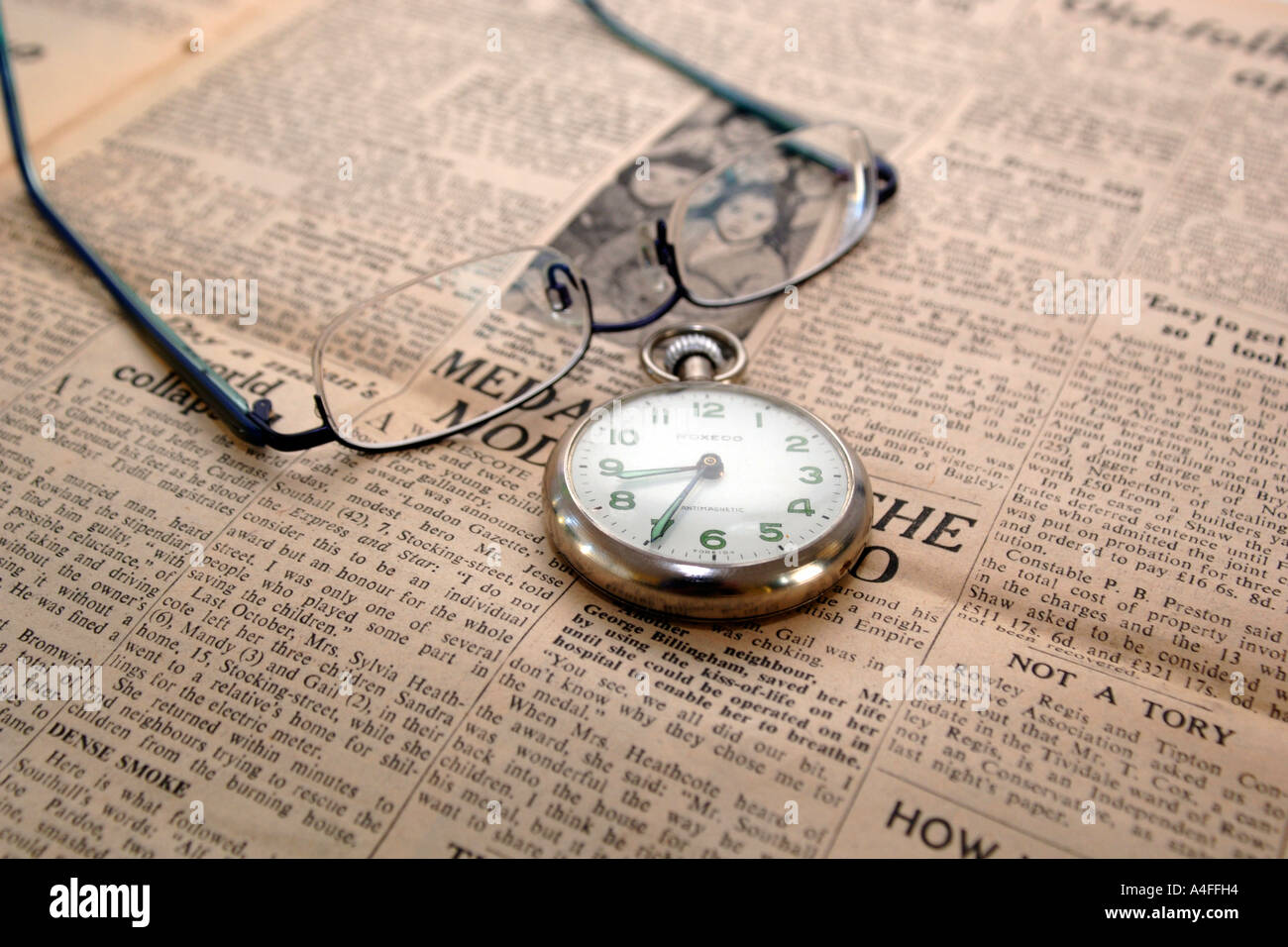 Pocketwatch on a newspaper with a pair of spectacles Stock Photo - Alamy