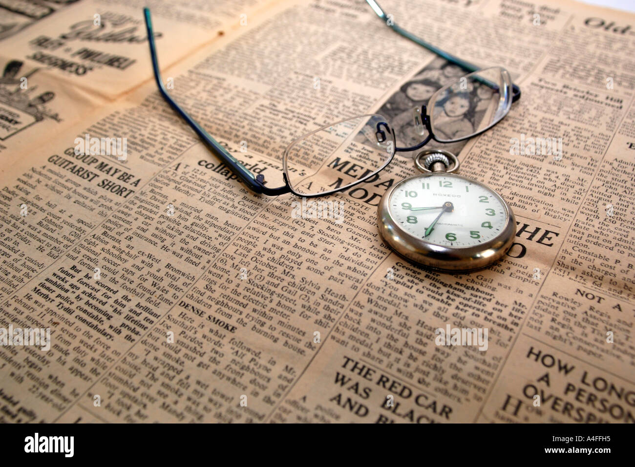 Pocketwatch on a newspaper with a pair of spectacles Stock Photo - Alamy