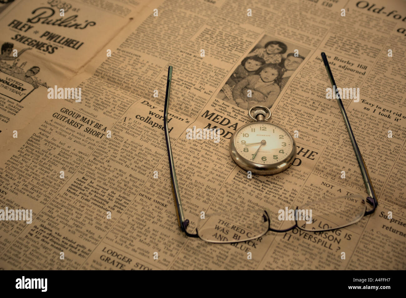 Pocketwatch on a newspaper with a pair of spectacles Stock Photo - Alamy