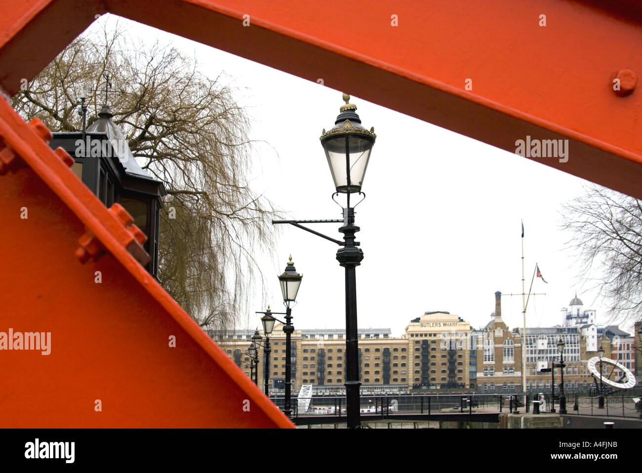 Butlers Wharf through red steel girders River Thames London England UK ...