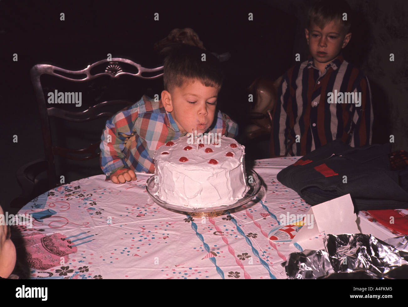 Vintage Photo of boy blowing out birthday candles Stock Photo - Alamy