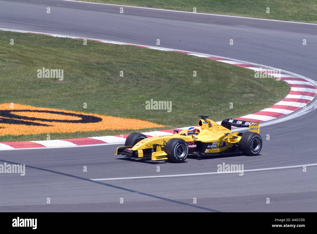 Yellow body Formula 1 racing car in race at turn Gilles Villeneuve ...