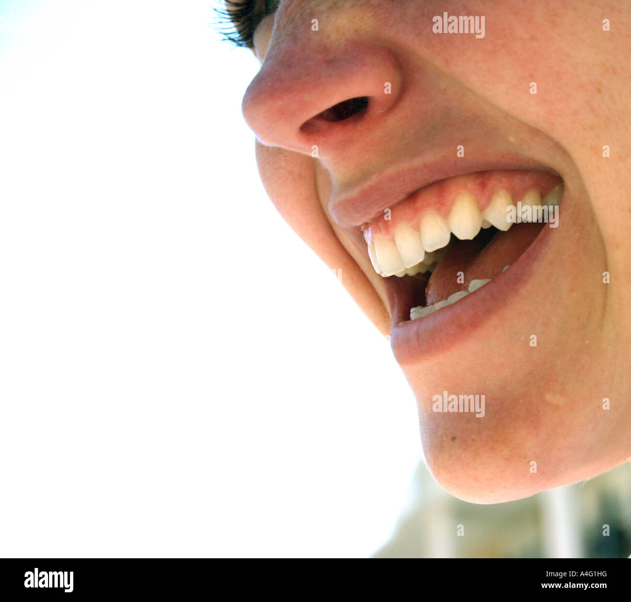 Beautiful woman shows off her pearly whites against a white background ...