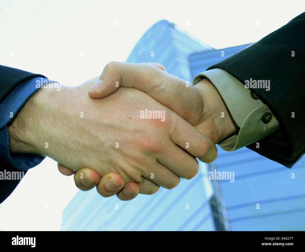 Business handshake in front of blue office building Stock Photo - Alamy