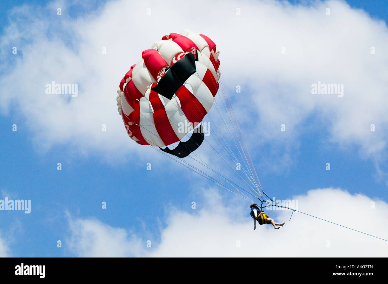 Parasailing high against blue sky and clouds Stock Photo - Alamy