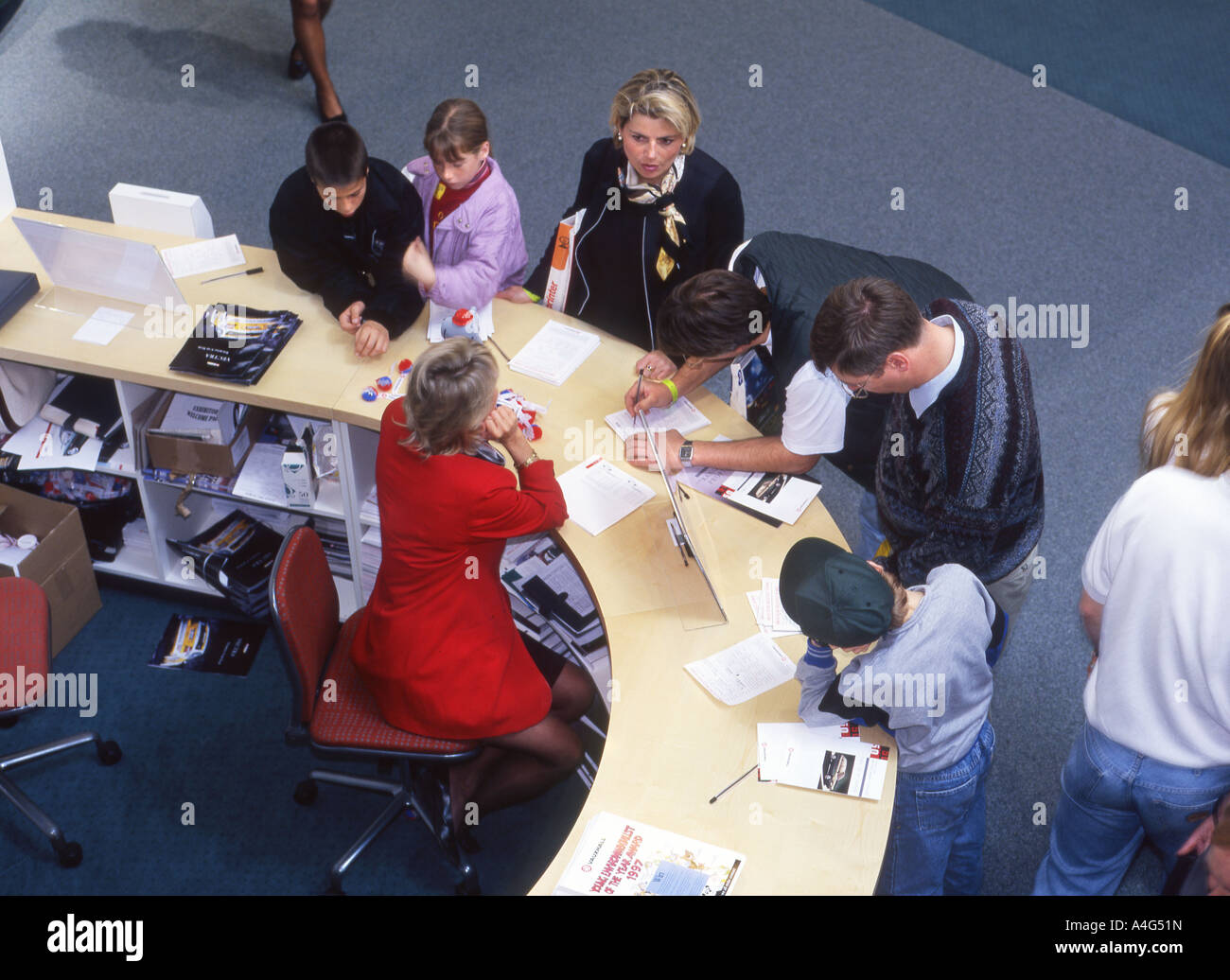 Number of visitors at a display desk in an exhibition Stock Photo - Alamy