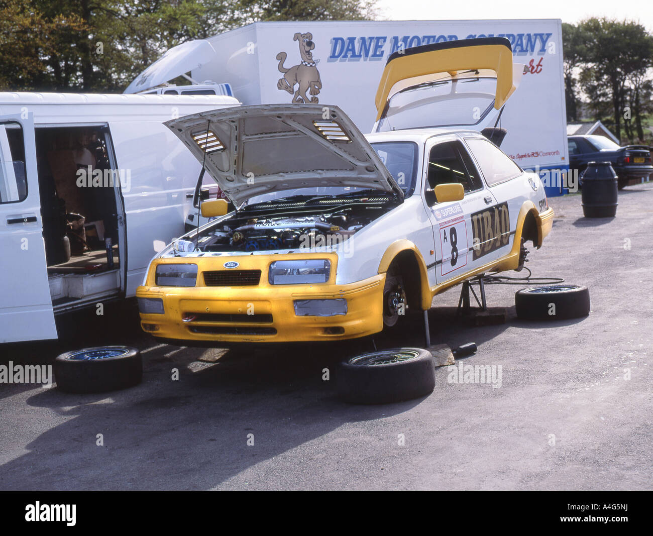 Sierra 4x4 rally car on axle stands being worked on in the pits prior ...