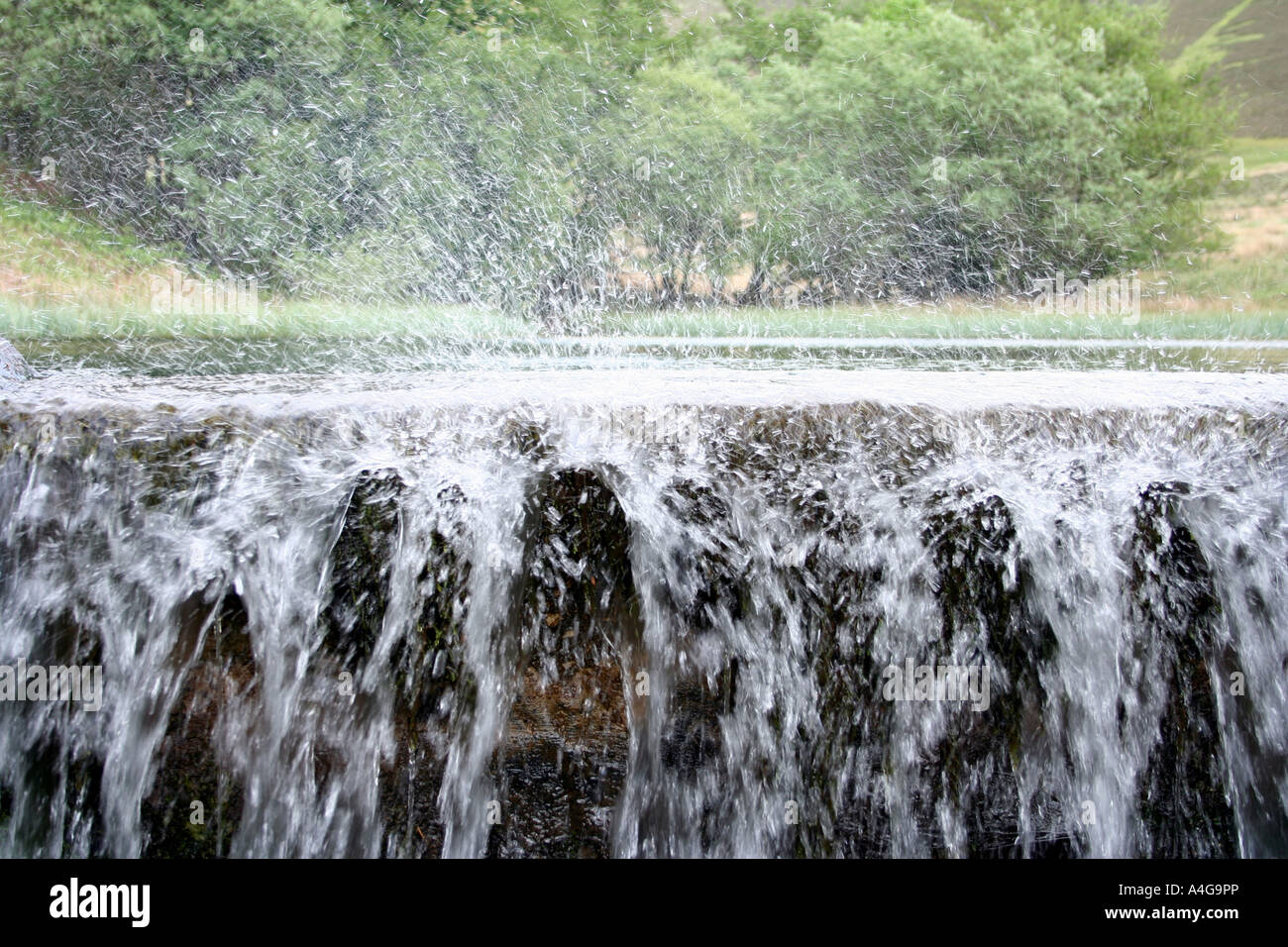 Weir at scottish river with falling water and spray in high winds Stock ...