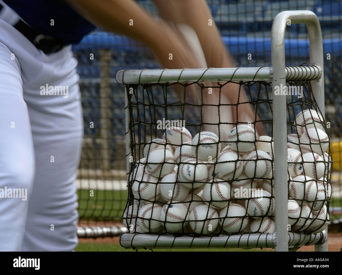 A baseball coach reaching into a basket of practice baseballs Stock Photo - Alamy