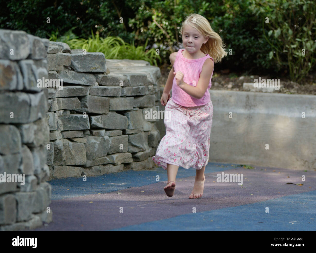 Young girl running in a playground Stock Photo - Alamy