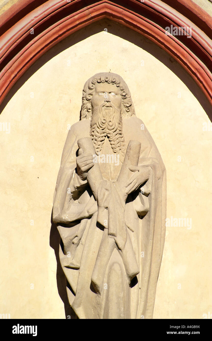 Gothic statue in niche under pointed arc on rim of gothic medieval ...