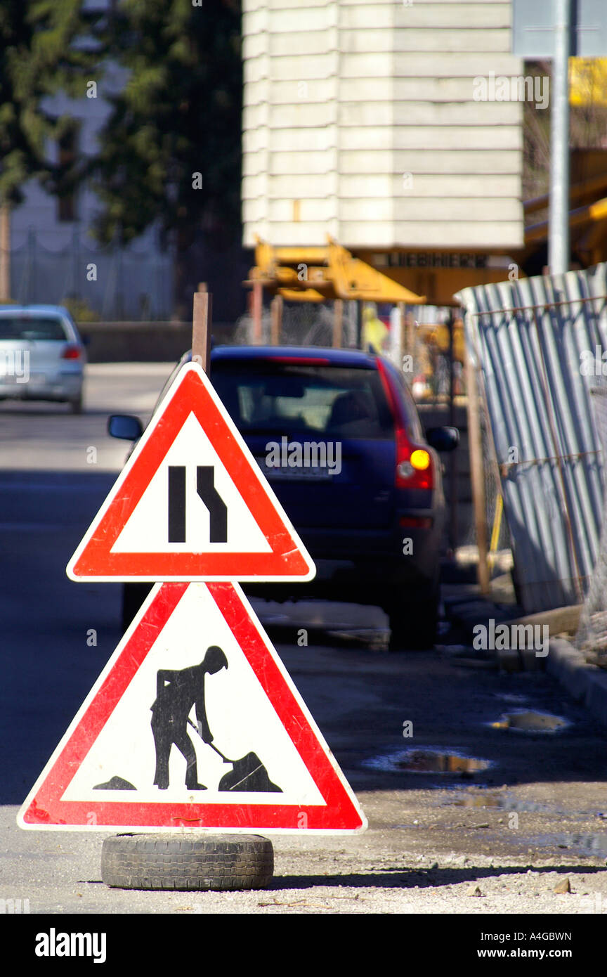 Construction in progress traffic sign on road and carss passing by in ...