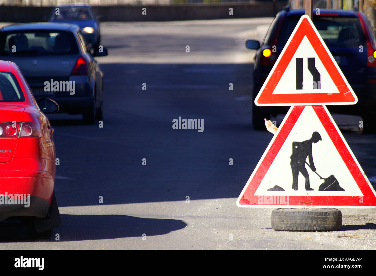 Construction in progress traffic sign on road and carss passing by in ...
