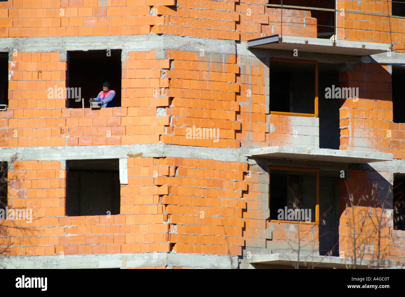 Construction site of brick wall building with openings for windows and ...