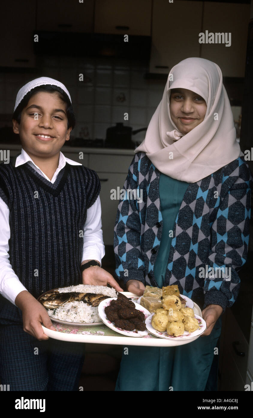 At the end of Ramadan young muslim brother and sister prepare meal to ...